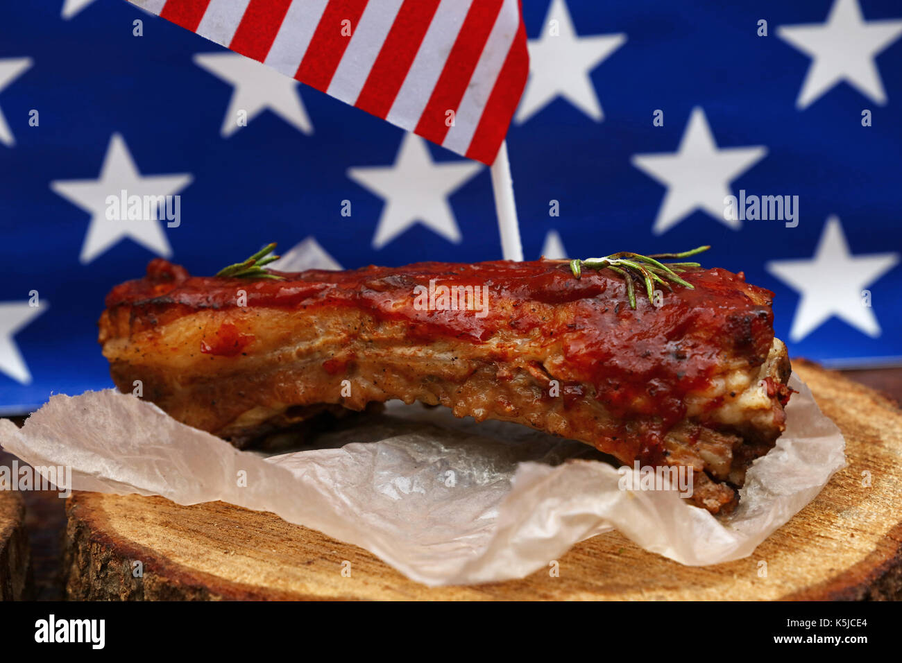 Portion of cooked pork spare ribs in bbq sauce on paper parchment and ...
