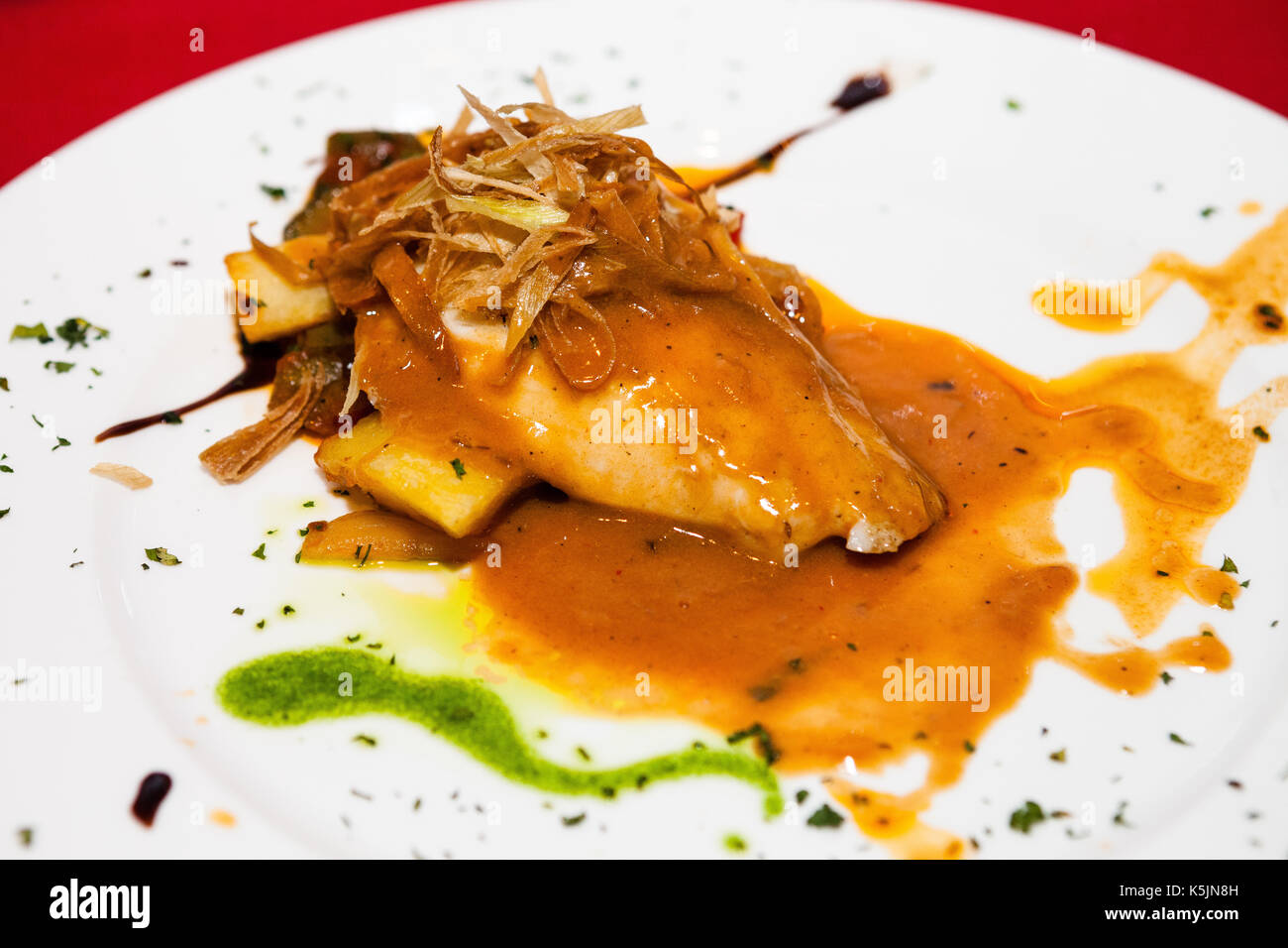 Fish with sauce and onion Stock Photo - Alamy