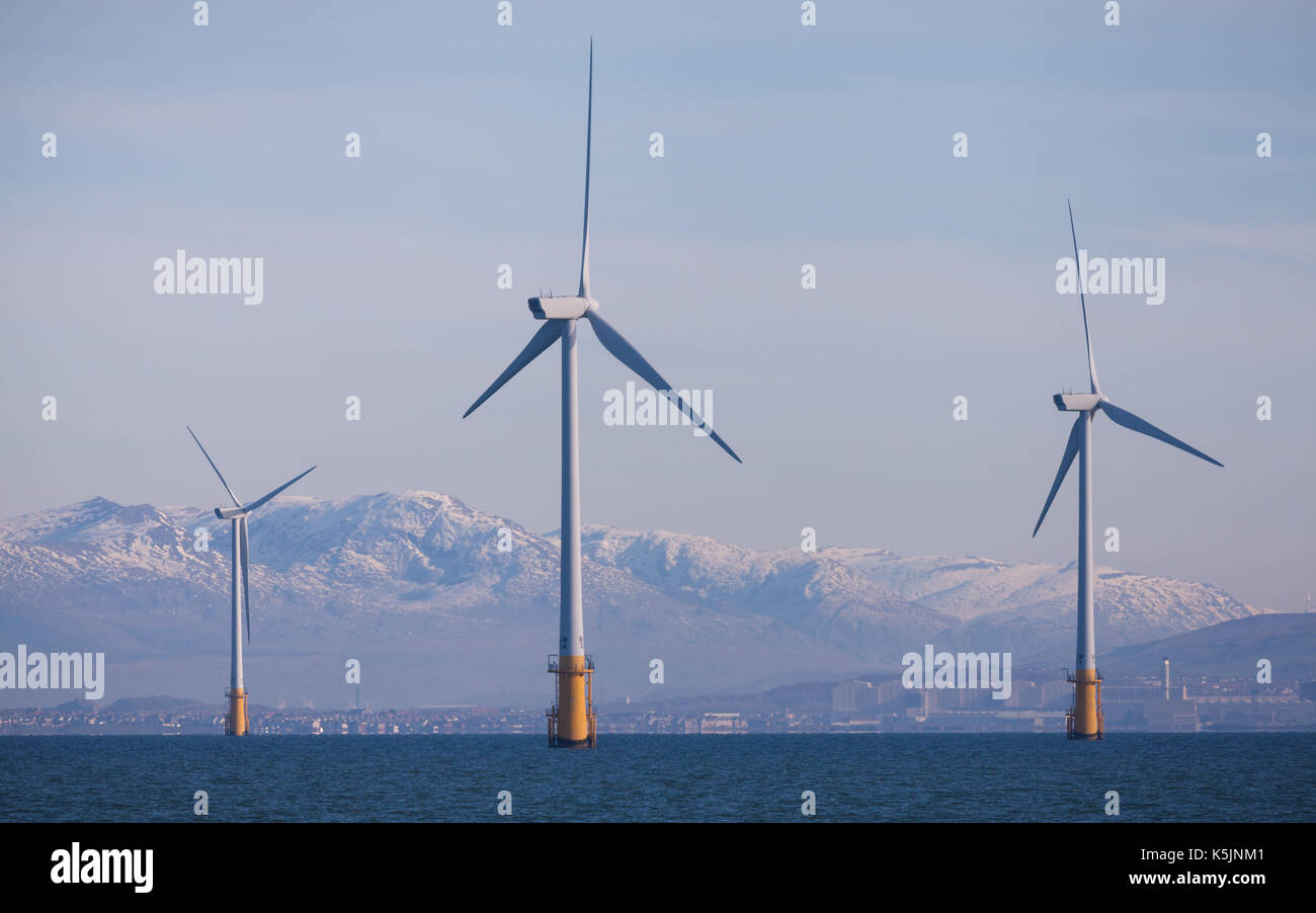 Turbines of Barrow Offshore Wind Farm with Barrow and snow-capped hills ...