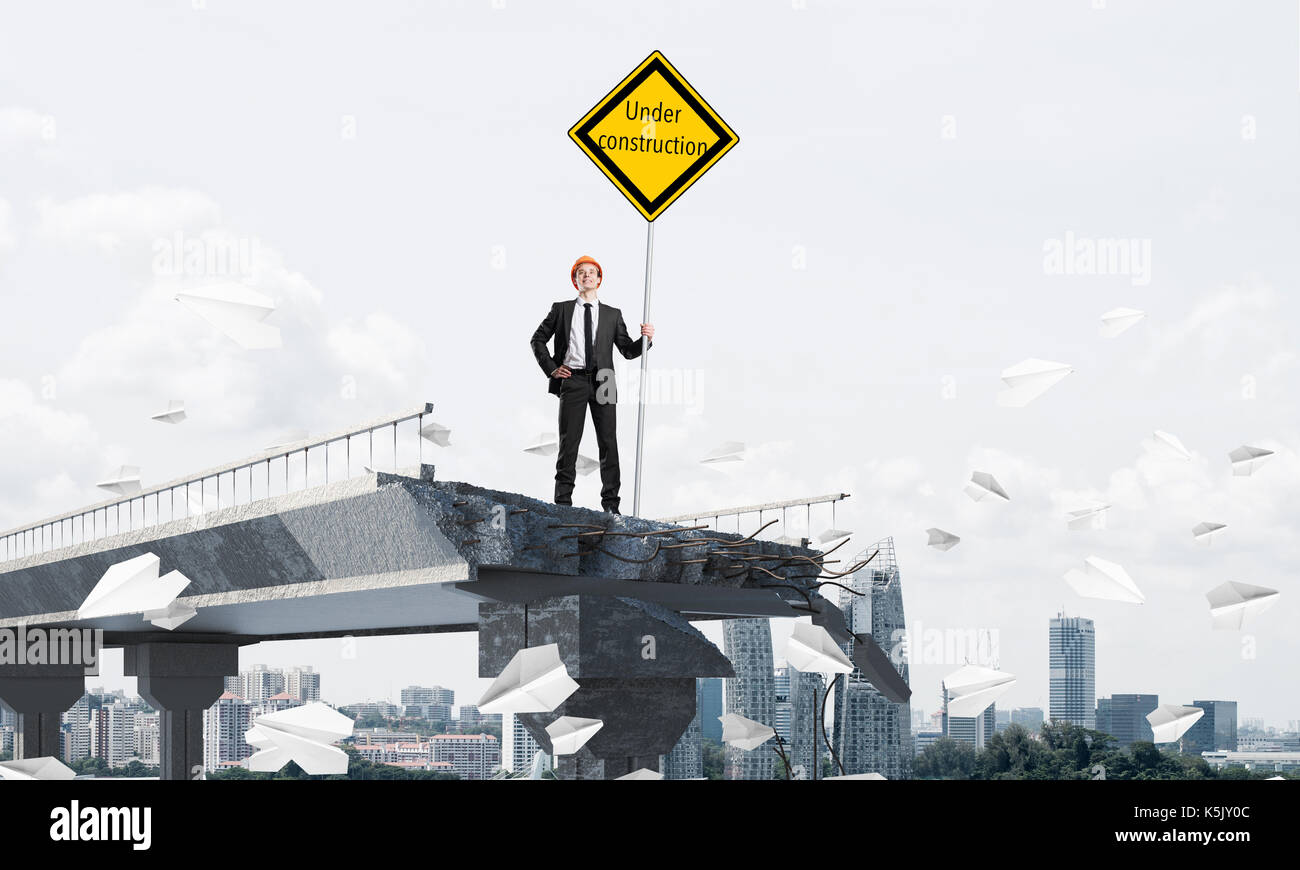 Confident engineer holding street safety sign Stock Photo - Alamy