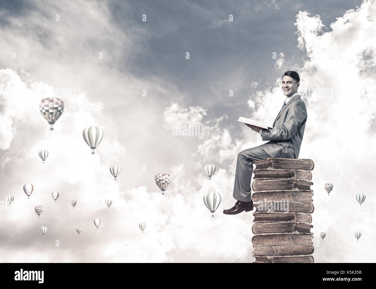 Man student reading book and aerostats flying around in air Stock Photo ...