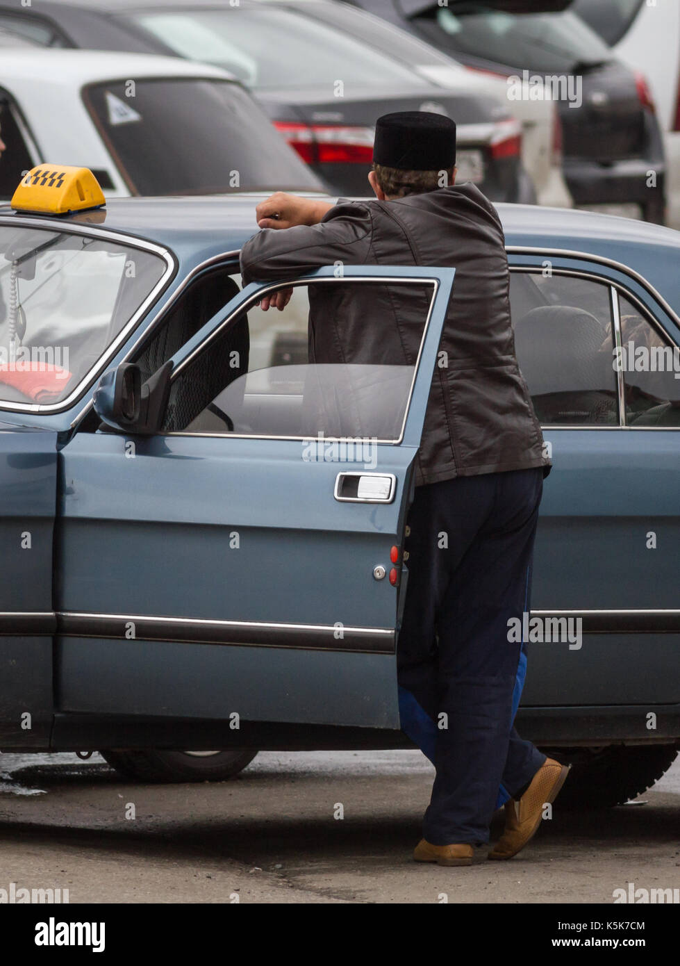 Russian illegal taxi and driver in tatar national hat, vertical Stock ...