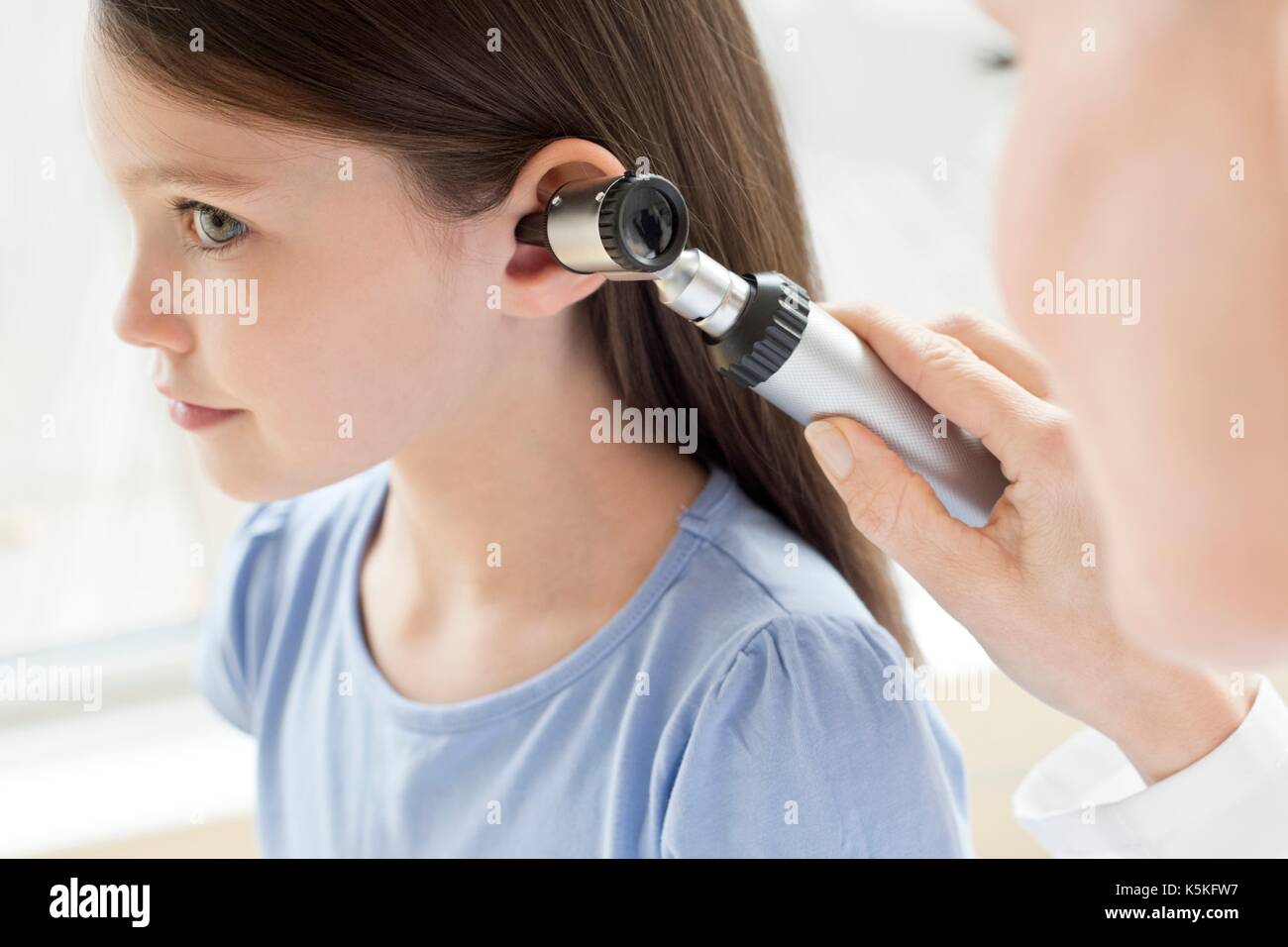 Female doctor examining girl's ear Stock Photo - Alamy