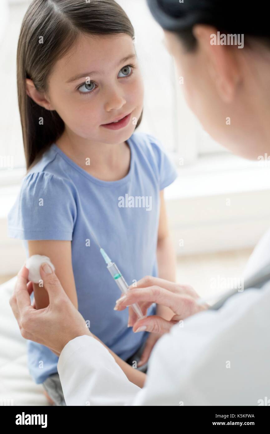 Female doctor giving girl injection Stock Photo - Alamy