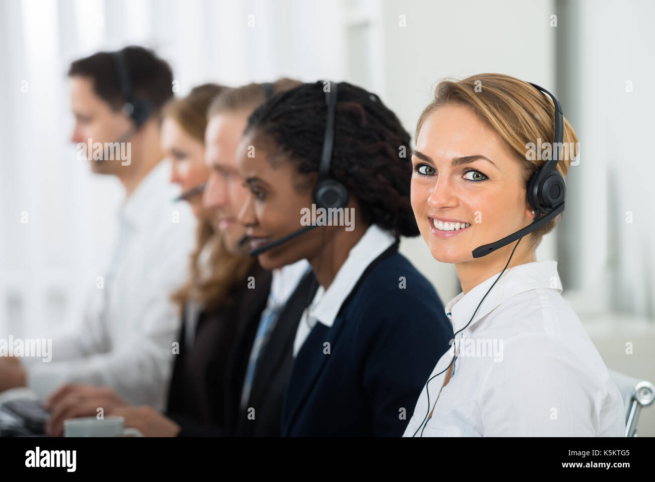 Call Center Operators In A Row Working On Computers In Office Stock ...