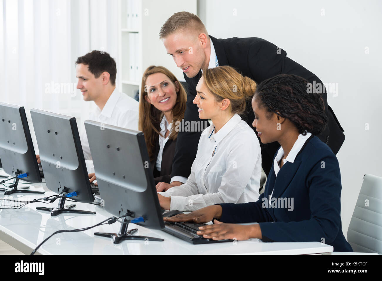 Young Businessman Helping His Colleagues In The Work Of Office Stock ...