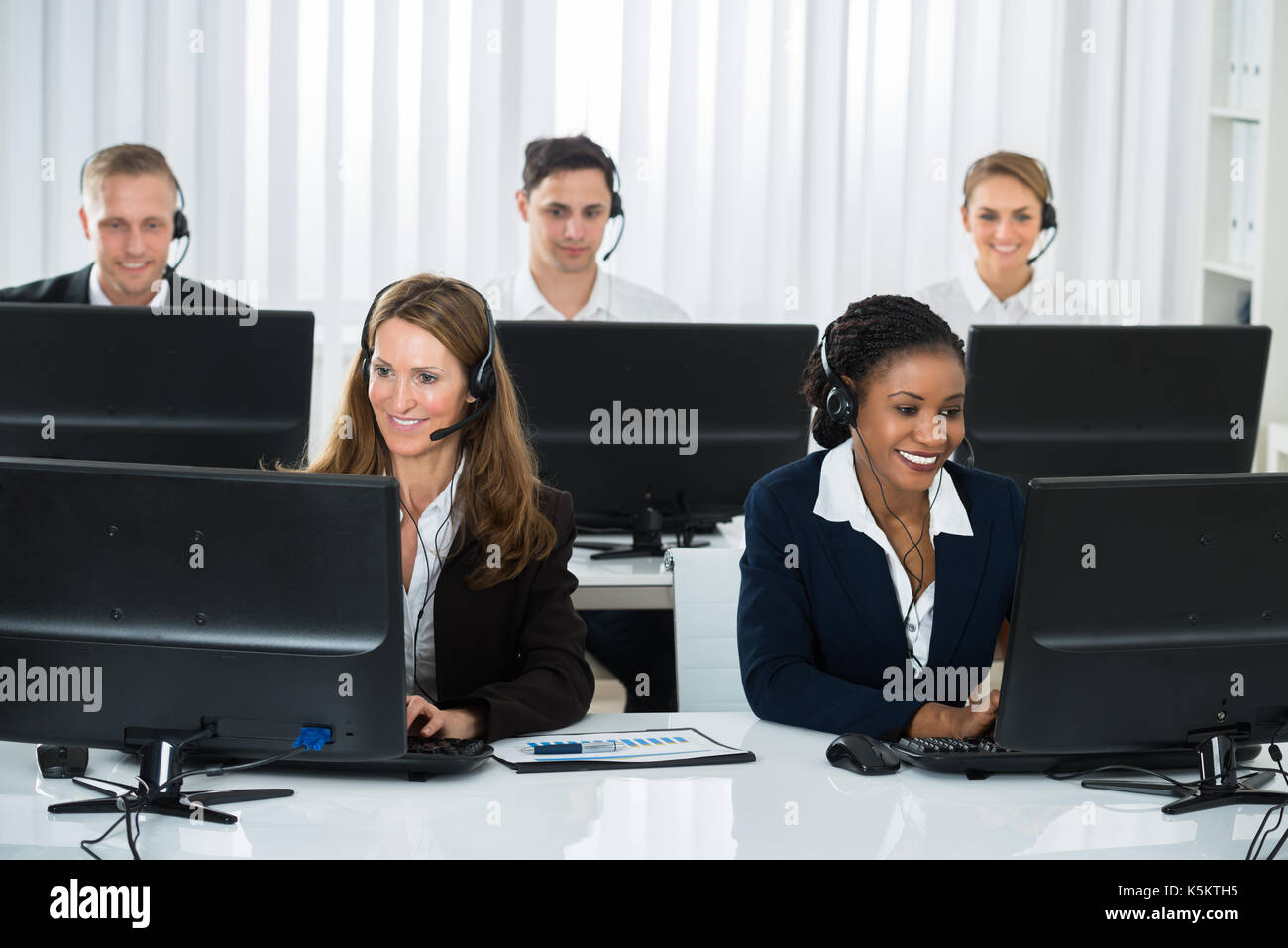 Team Of Professional Businesspeople Working On Computers In Call Center ...