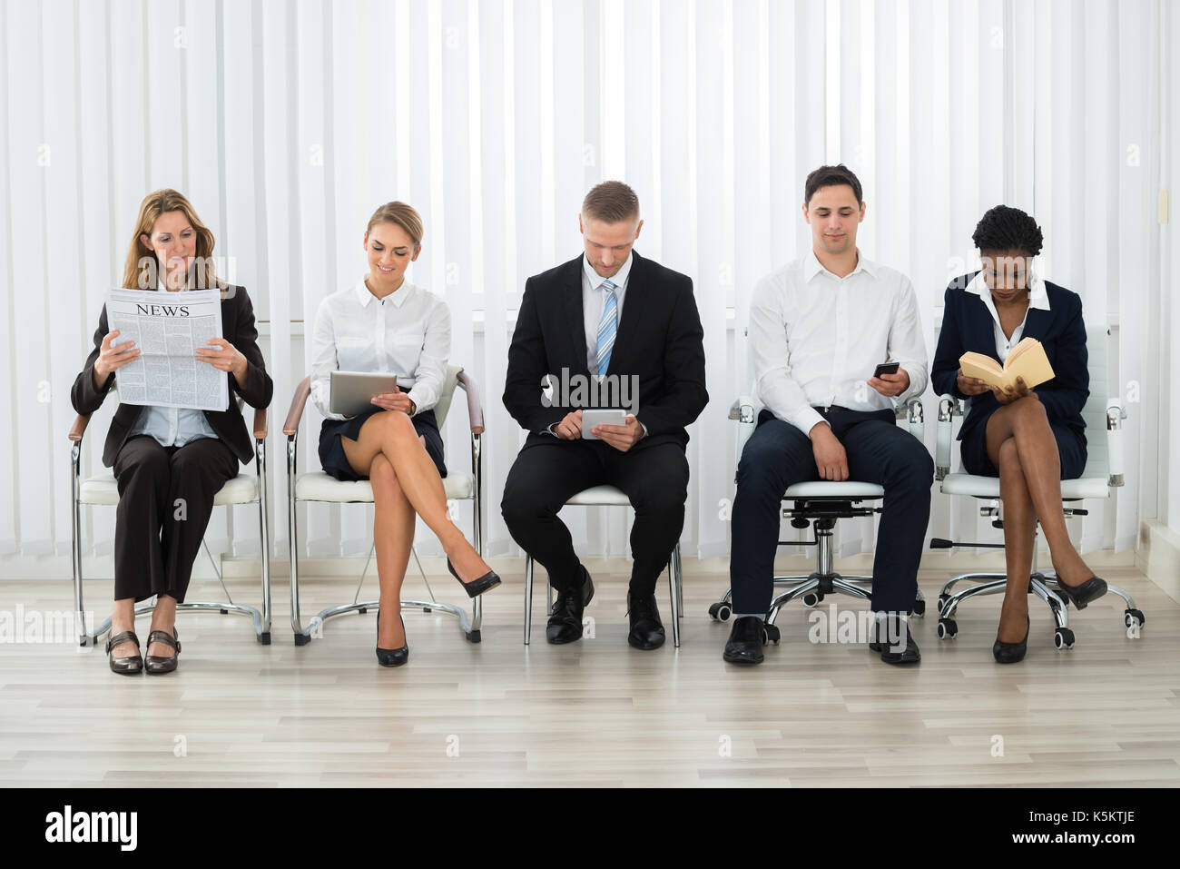 Group Of Businesspeople Doing Various Activities While Waiting For ...