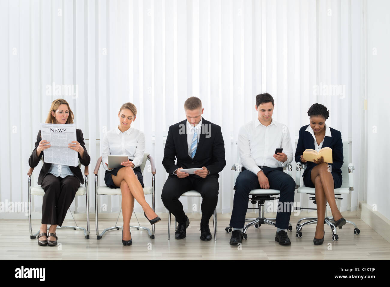 Group Of Businesspeople Doing Various Activities While Waiting For ...