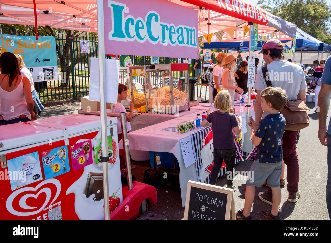 Ice cream stall at a primary school fete in Sydney, father and son at ...