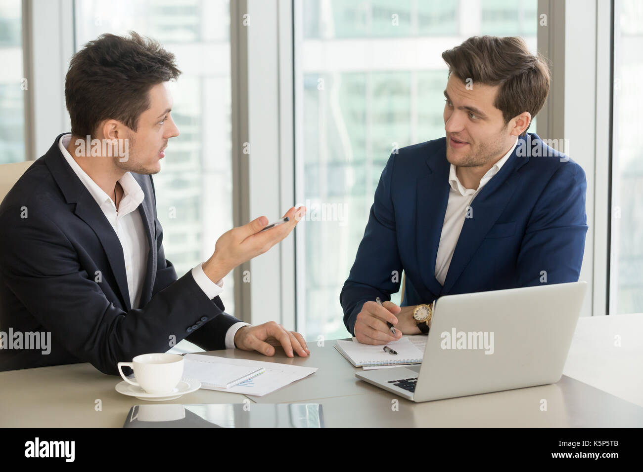 Young businessman convincing experienced colleague Stock Photo - Alamy