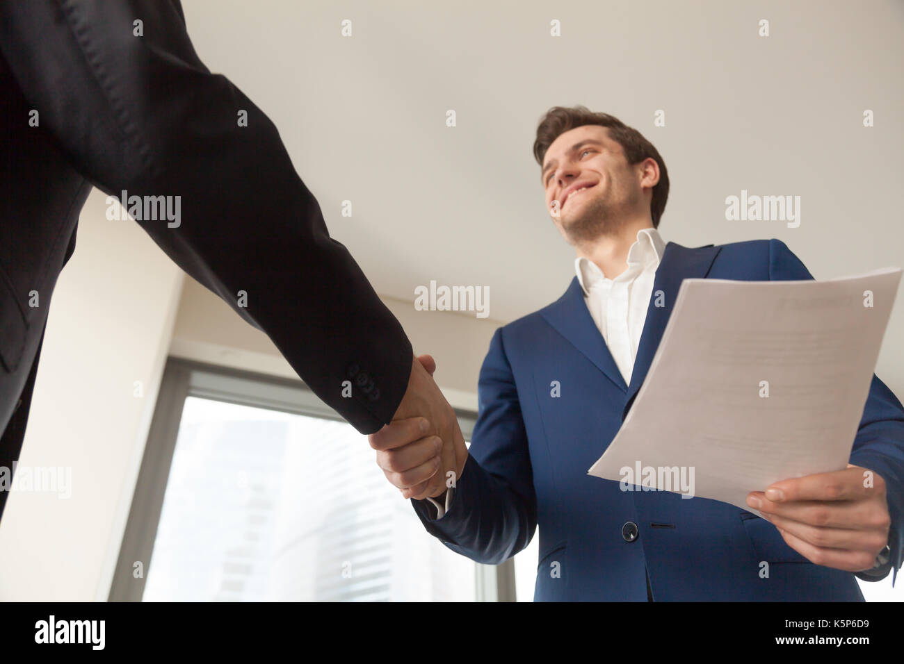 Smiling company manager welcoming client in office Stock Photo - Alamy
