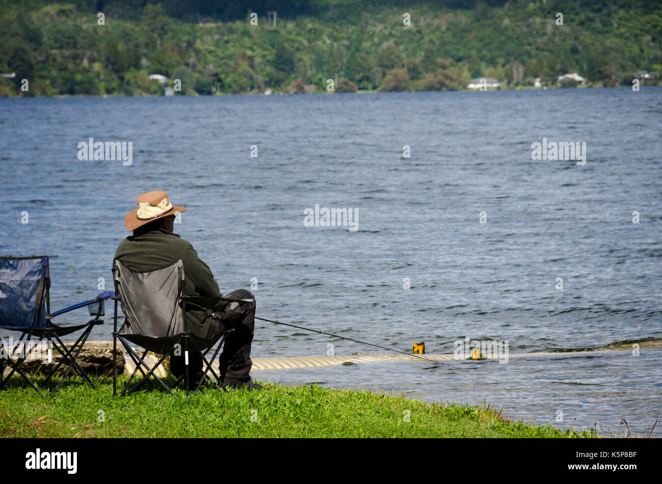 Man fishing beside Lake Rotoiti, Bay Of Plenty, New Zealand Stock Photo ...