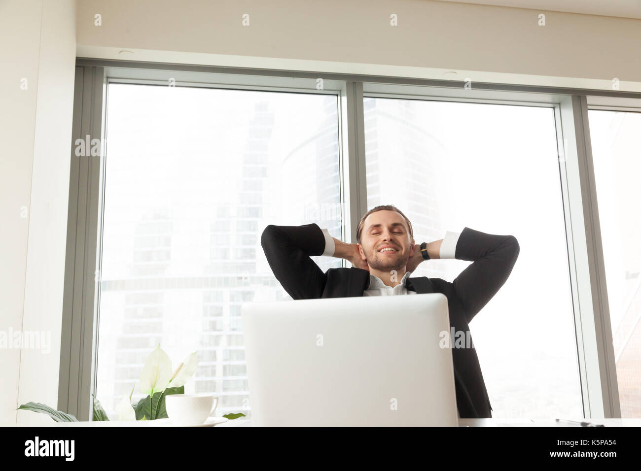 Happy businessman relaxing at workplace in modern office Stock Photo ...
