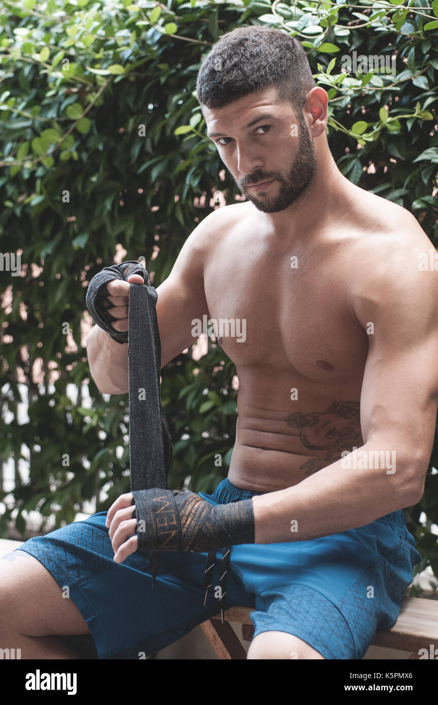 Muscular male boxer wraps his hands in bandages Stock Photo - Alamy