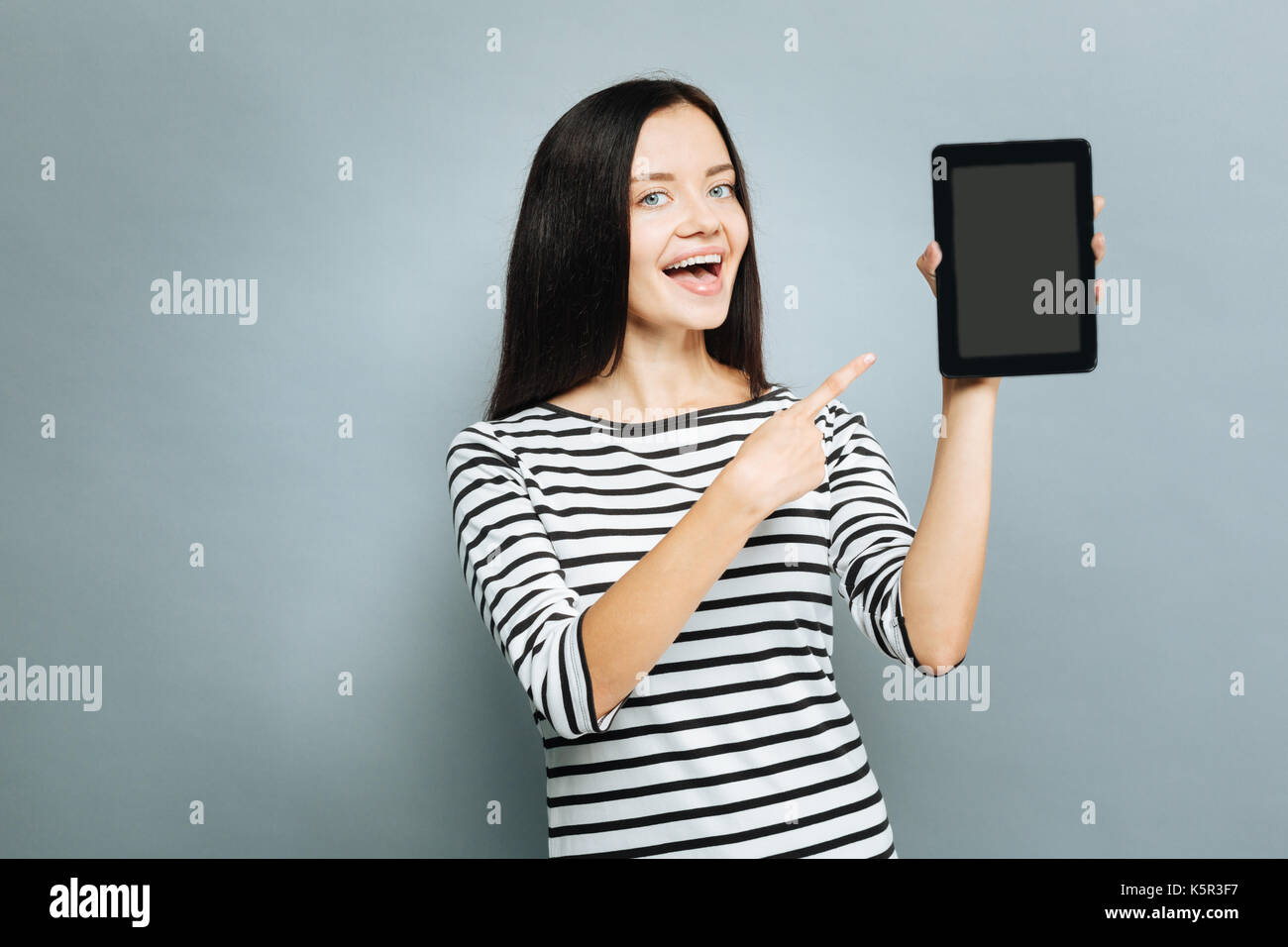 Pretty girl pointing at her tablet Stock Photo - Alamy