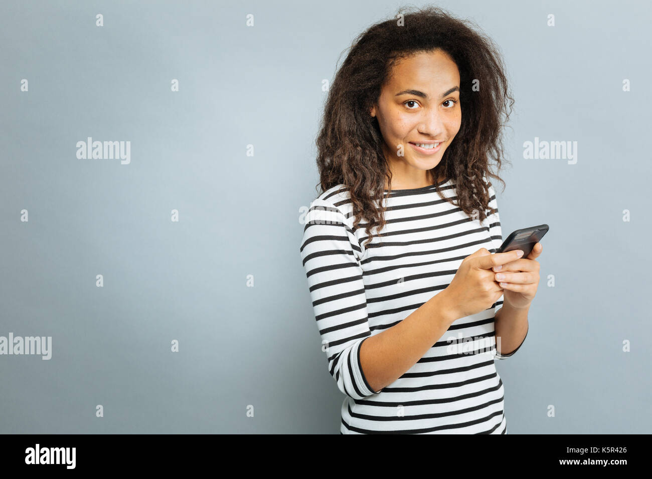 Concentrated girl using her phone Stock Photo - Alamy