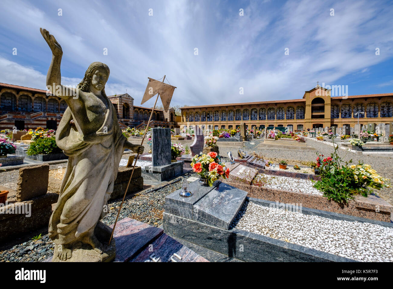 A statue, graves and buildings of the cemetary in town Stock Photo - Alamy