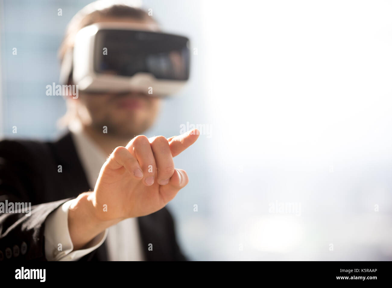 Businessman in VR glasses pointing finger in the air Stock Photo - Alamy