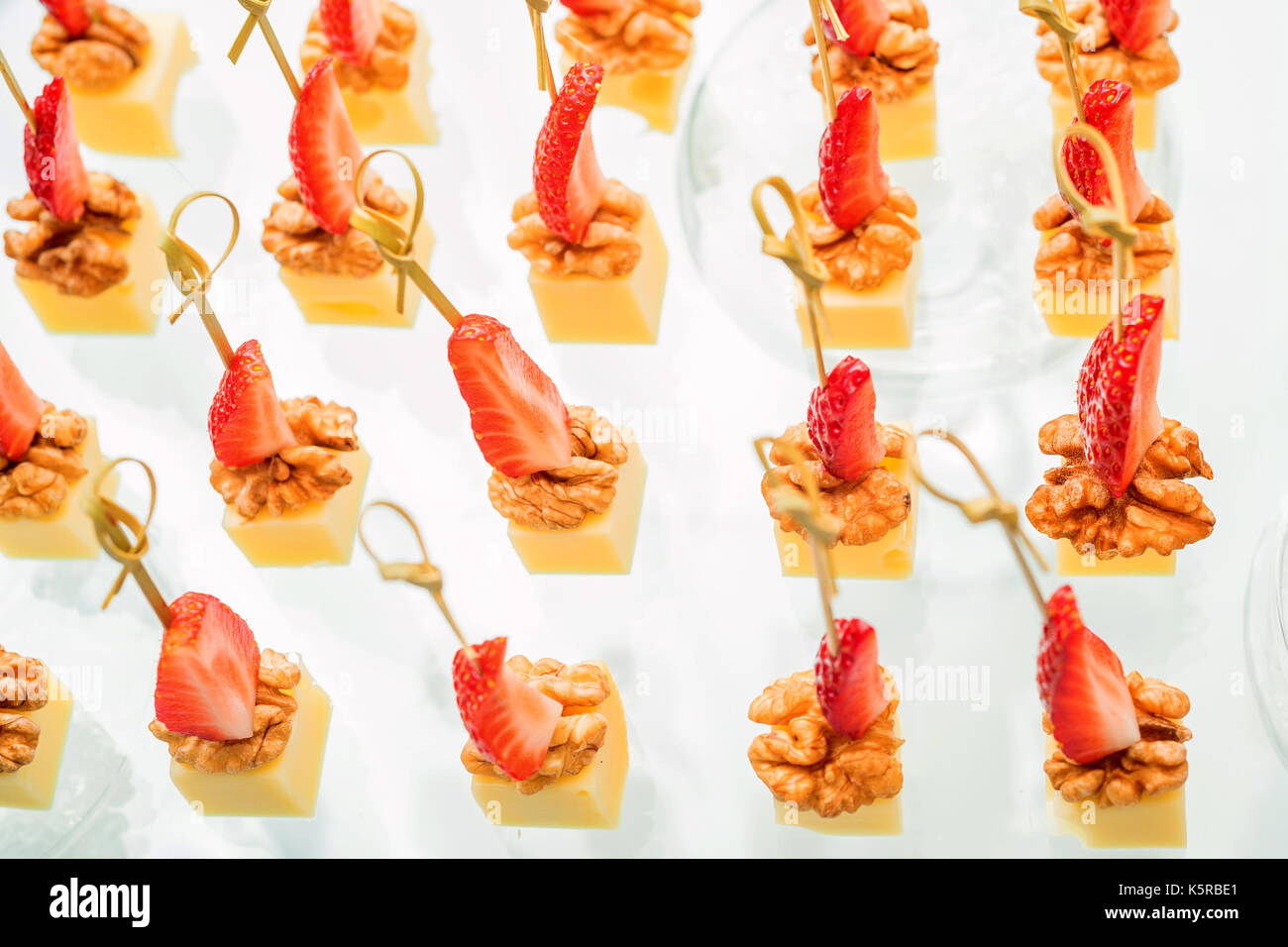 Appetizer of cheese cubes, stawberry and walnut Stock Photo - Alamy