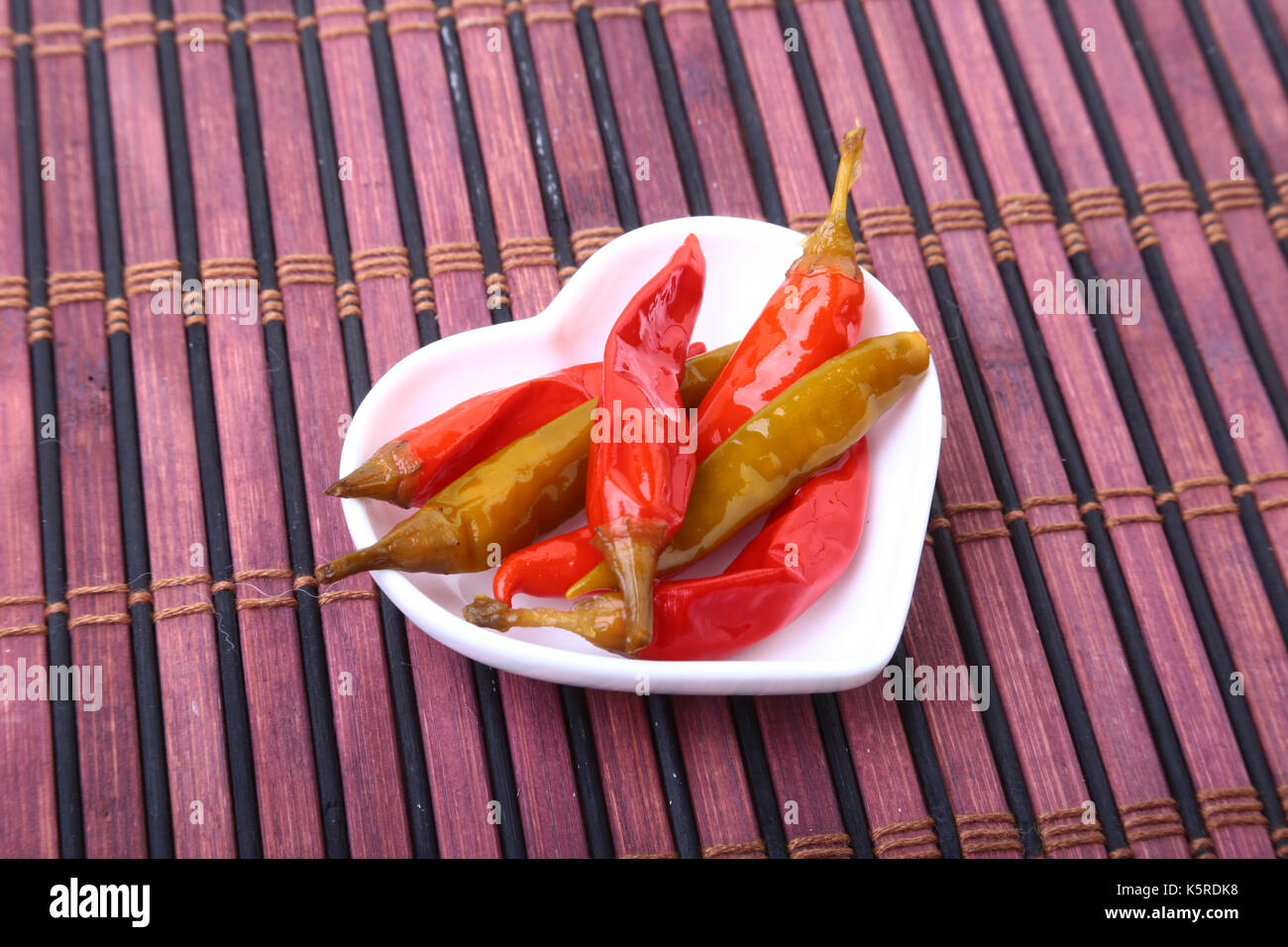 Bowl of pickled Red hot chili peppers on wooden background Stock Photo ...