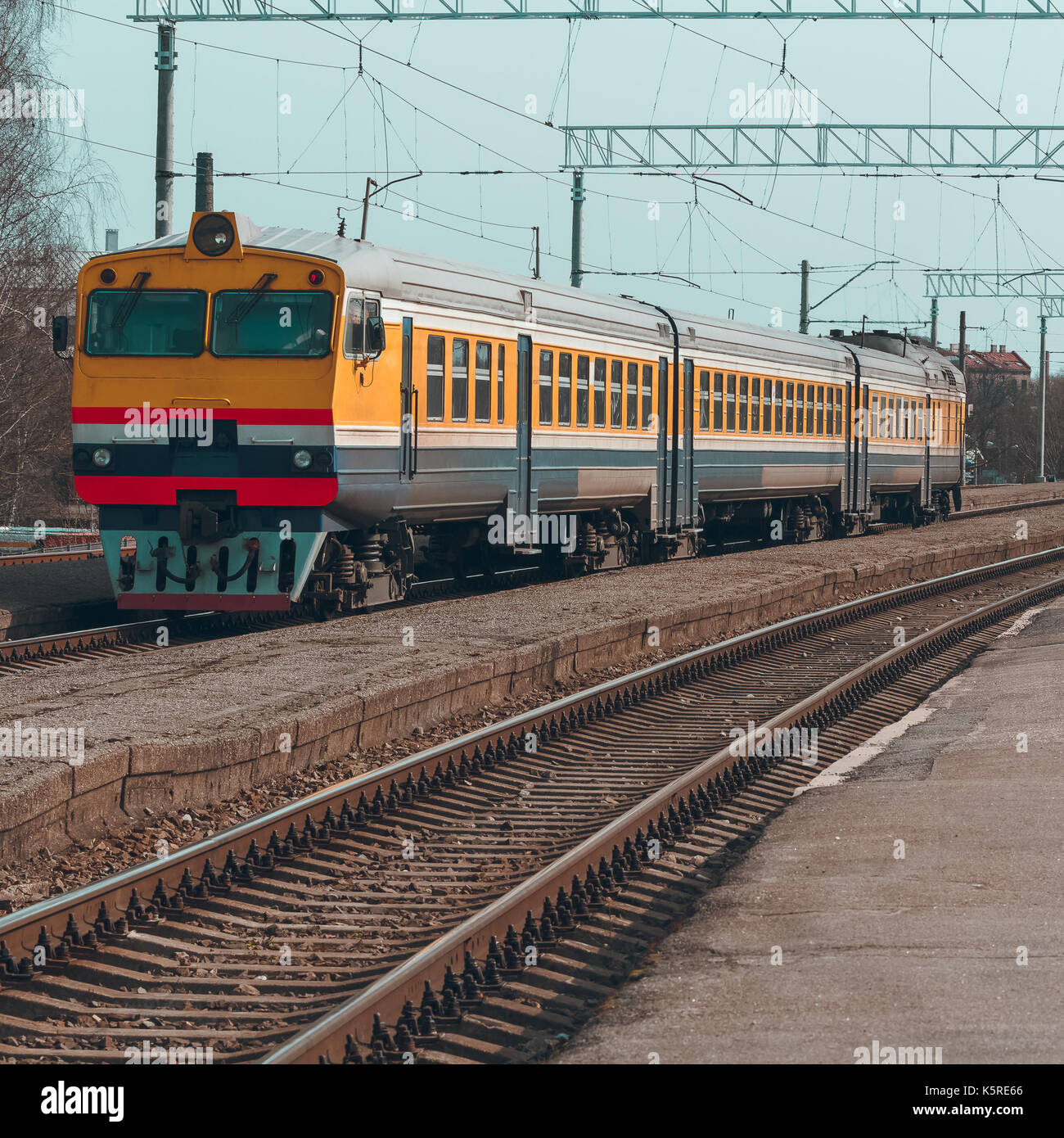 Old yellow passenger diesel train moving at the terminal Stock Photo ...