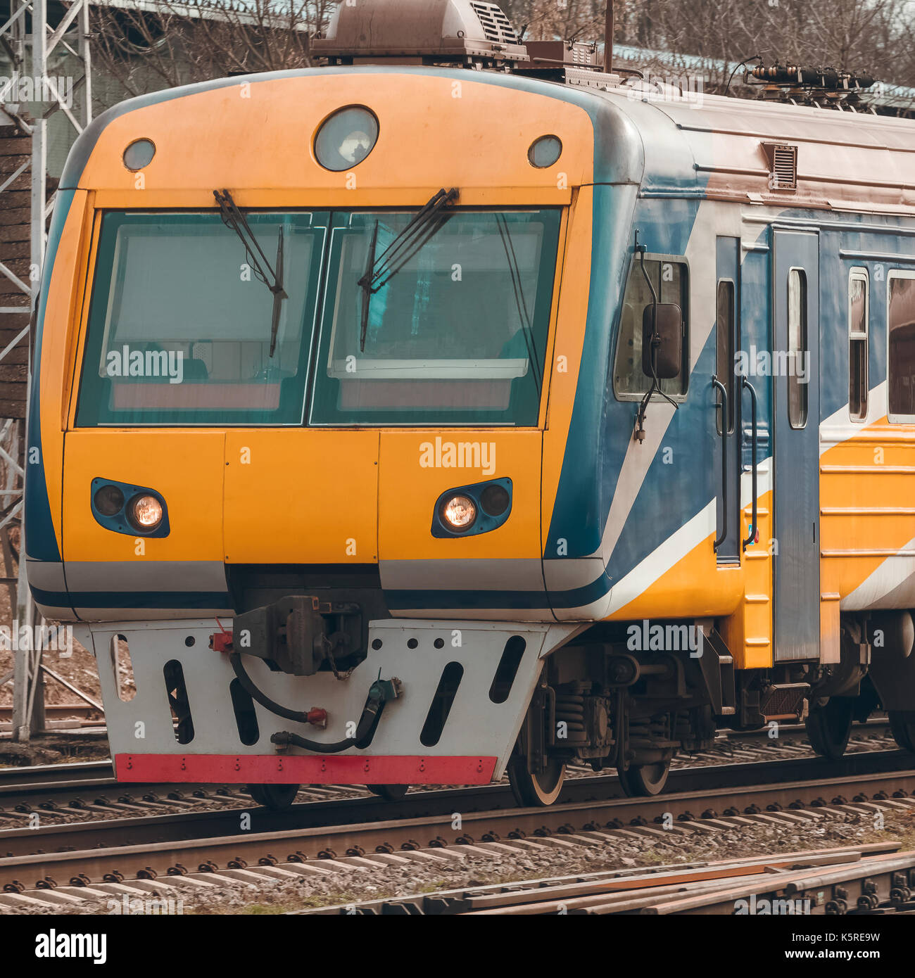 Yellow modern passenger electric train moving at the old terminal Stock ...
