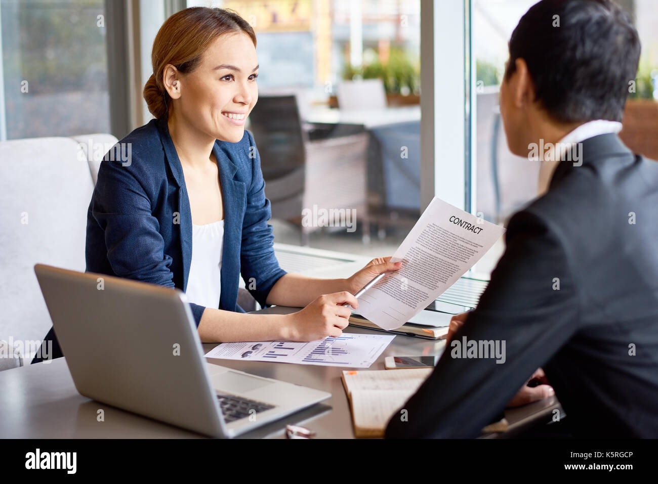 Business partners discussing details of mutually beneficial cooperation before signing contract ...