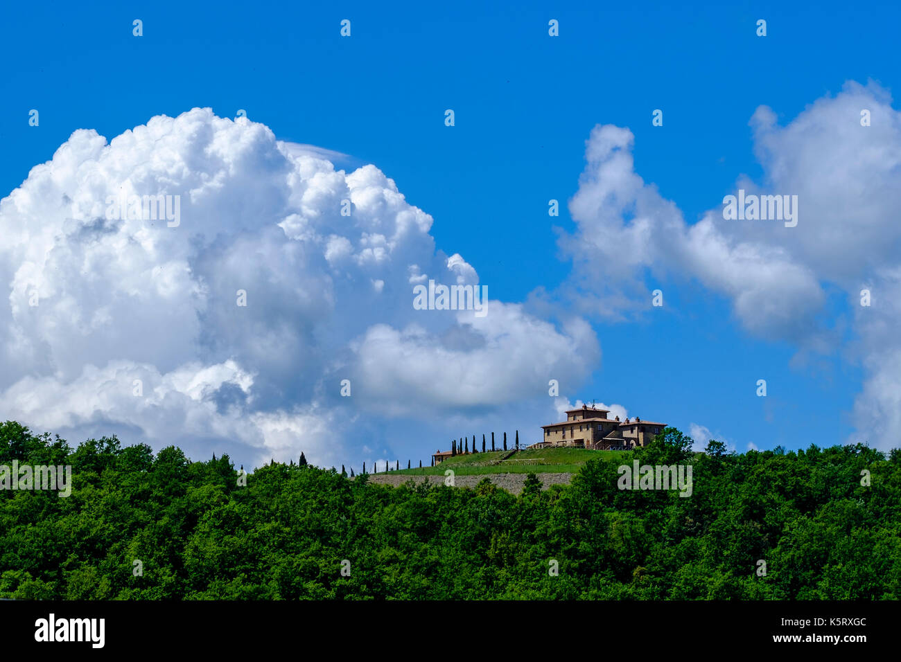 Typical tuscanian landscape with a farmhouse on a hill, cypresses ...