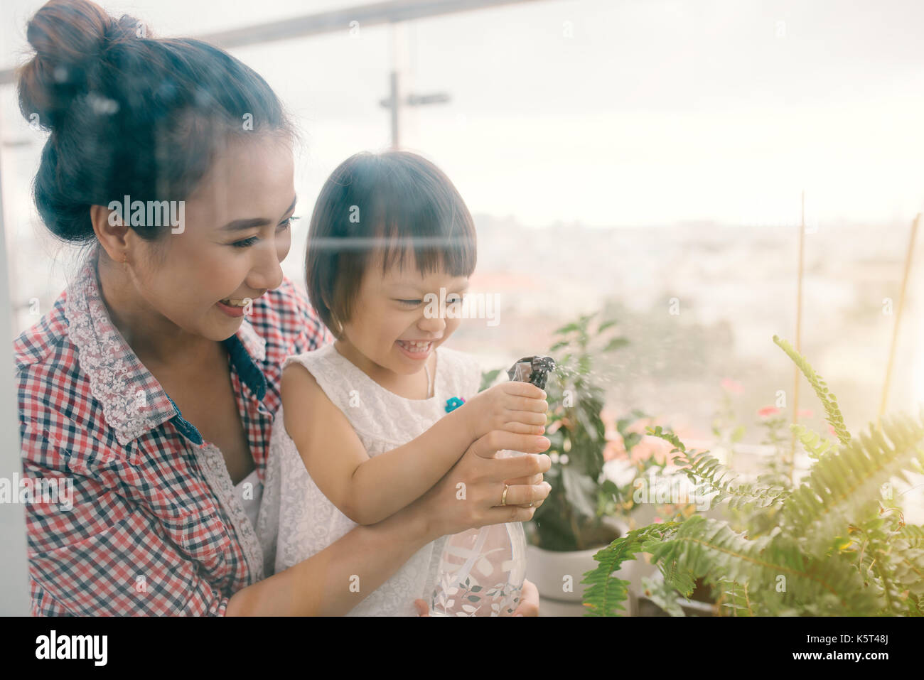 Happy mother and child daughter water in small garden Stock Photo - Alamy