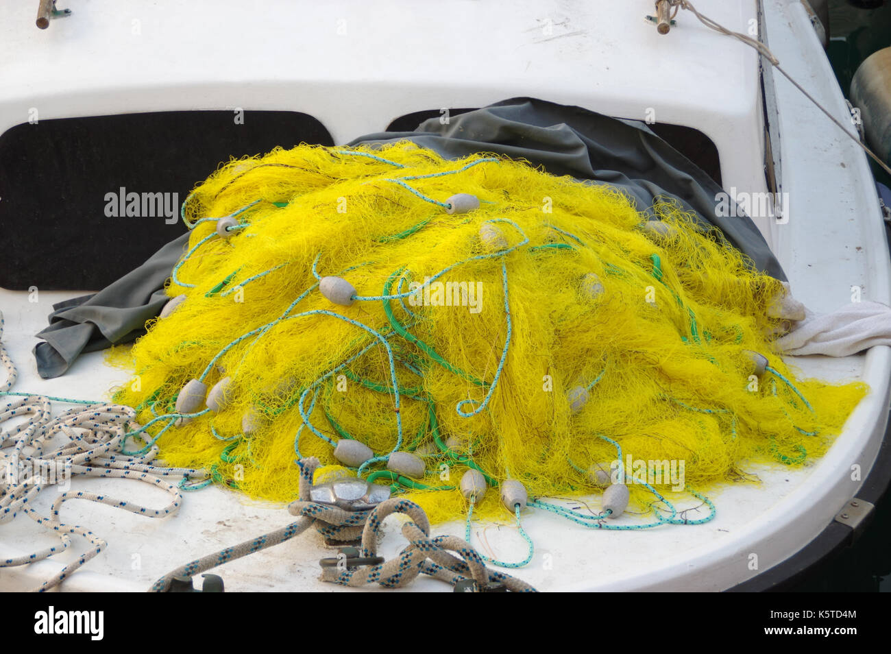 Tangled yellow fishing net on board Stock Photo - Alamy
