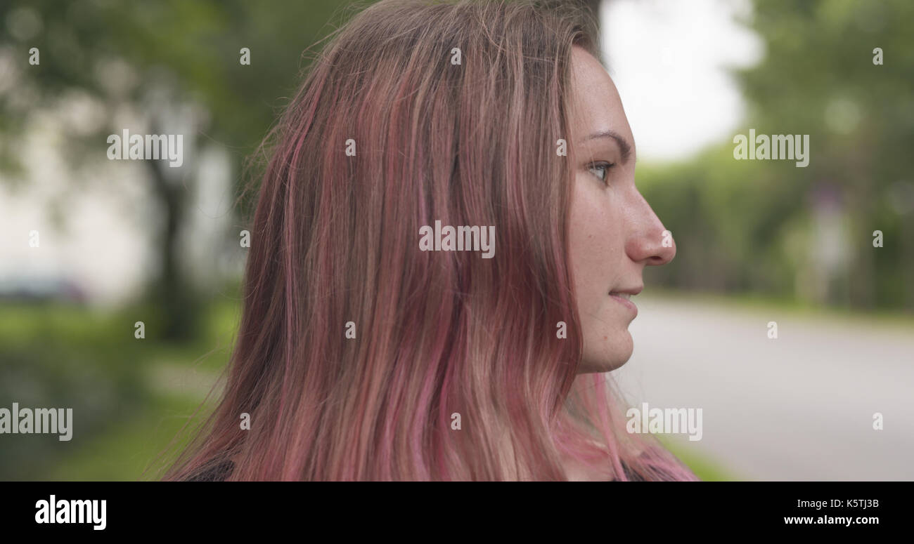 happy teen girl with purple hair standing in town side view, wide photo ...