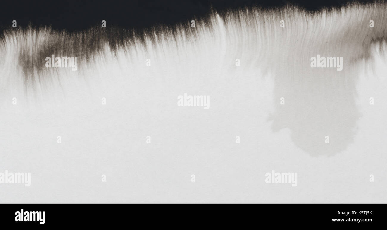 closeup black ink border spreading on wet paper top view, wide photo ...