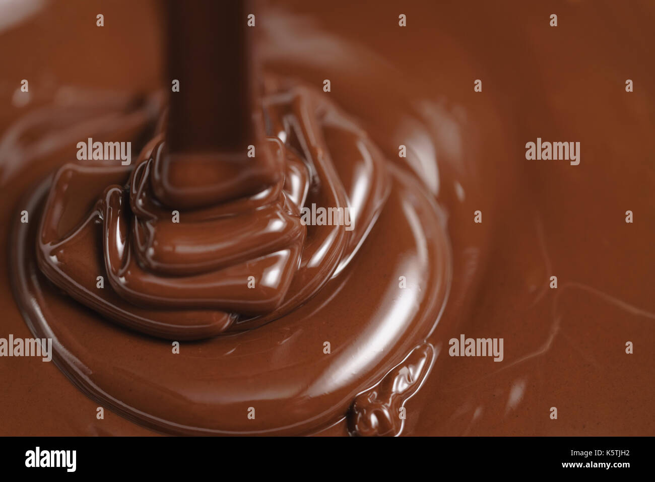 pouring melted premium dark chocolate, sweet food background Stock ...