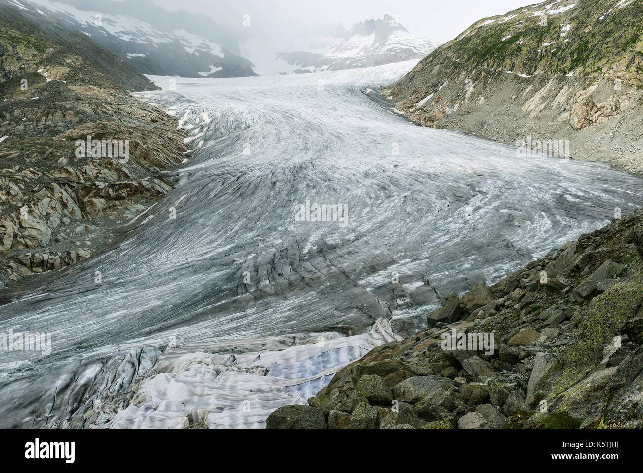 Rhone glacier in clouds, at bottom white cloths against the melting of ...