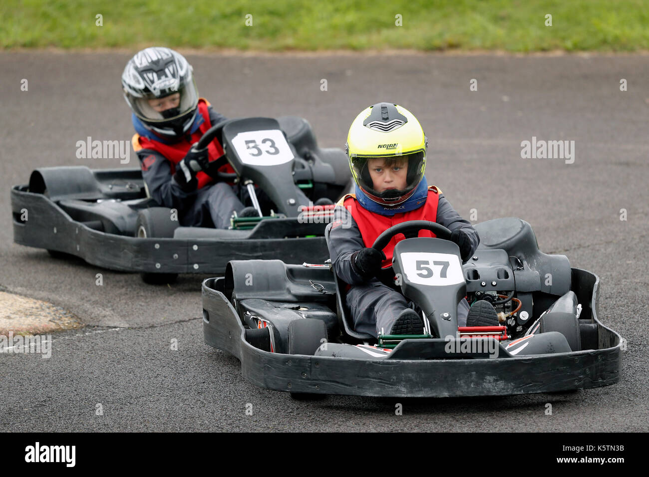 Young boys learn to drive karts on a track during a Junior Karting ...