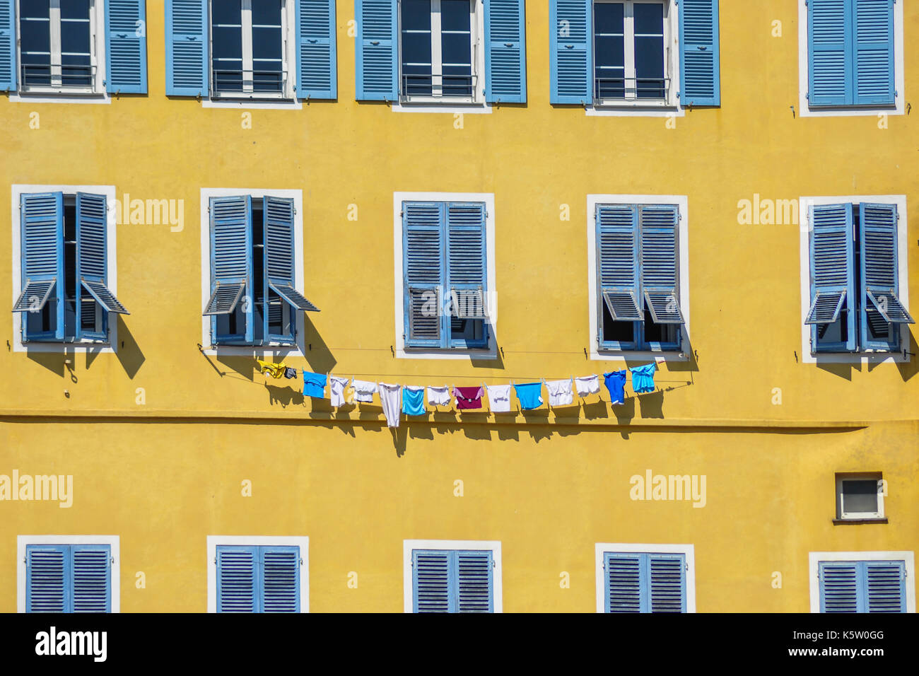 A photo gallery of laundry hangs out to dry between blue-shuttered ...