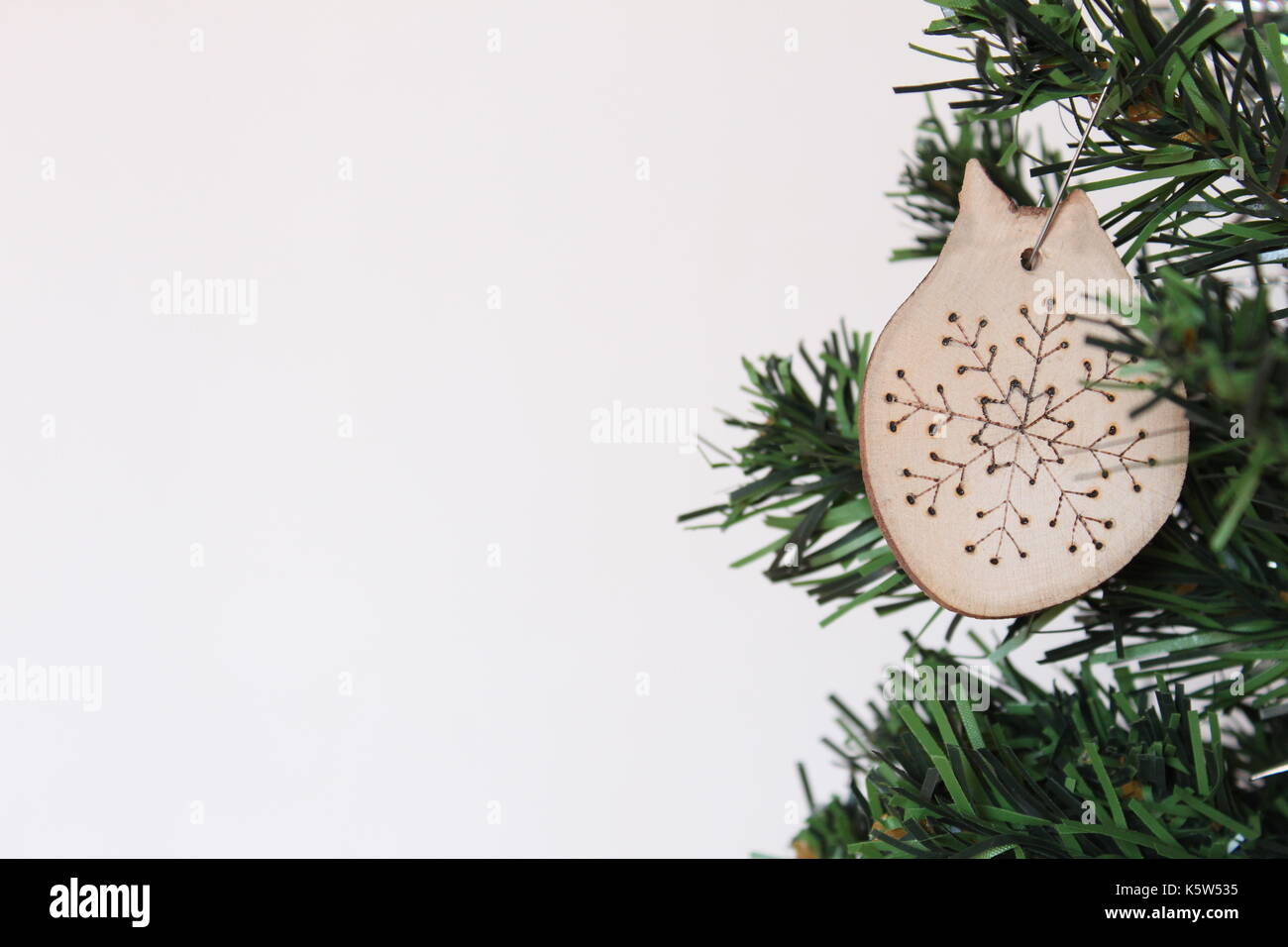 Handmade pyrography snowflake ornament on a Christmas tree with white ...