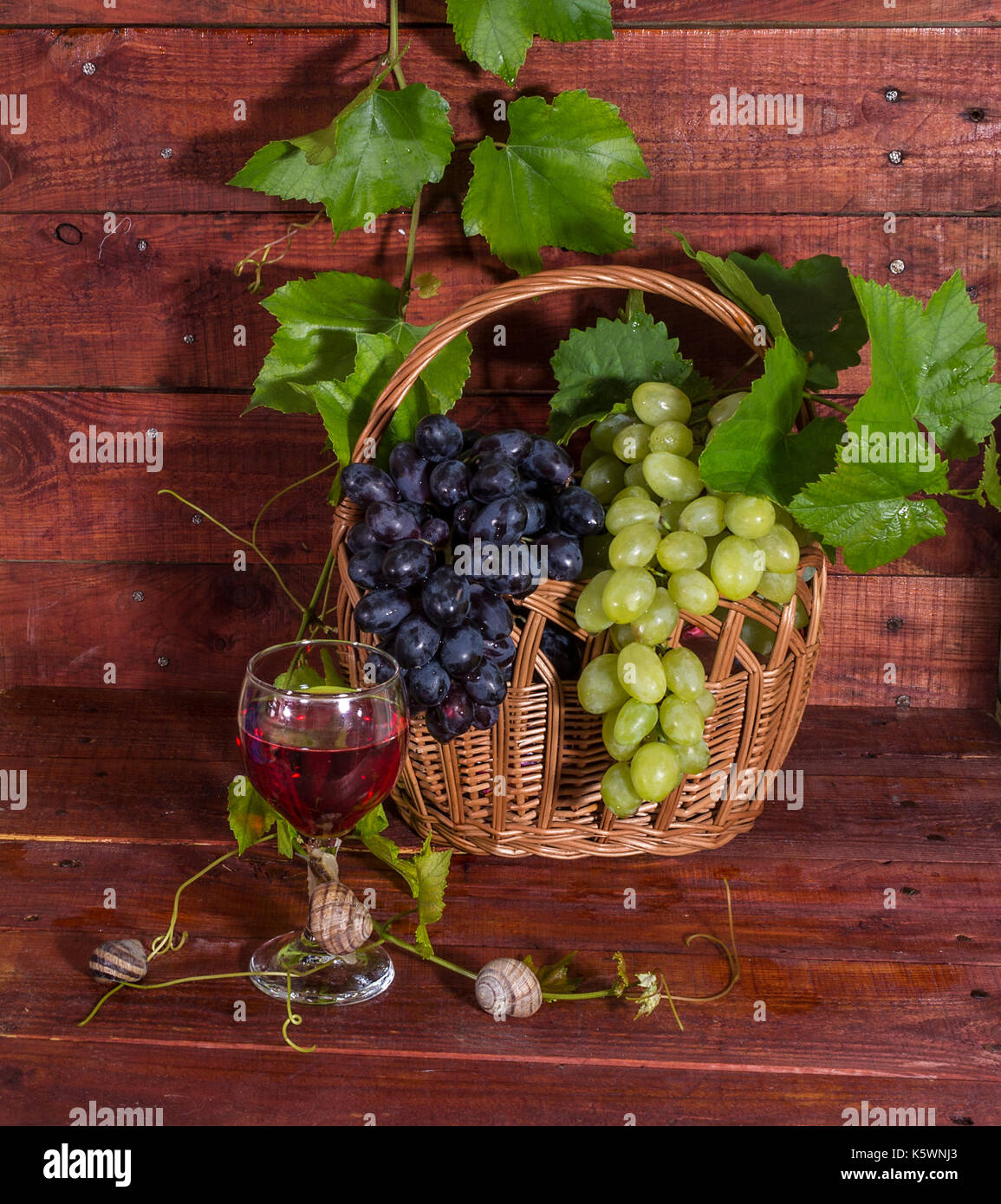 Grapes, red wine and vine on a wooden table Stock Photo - Alamy