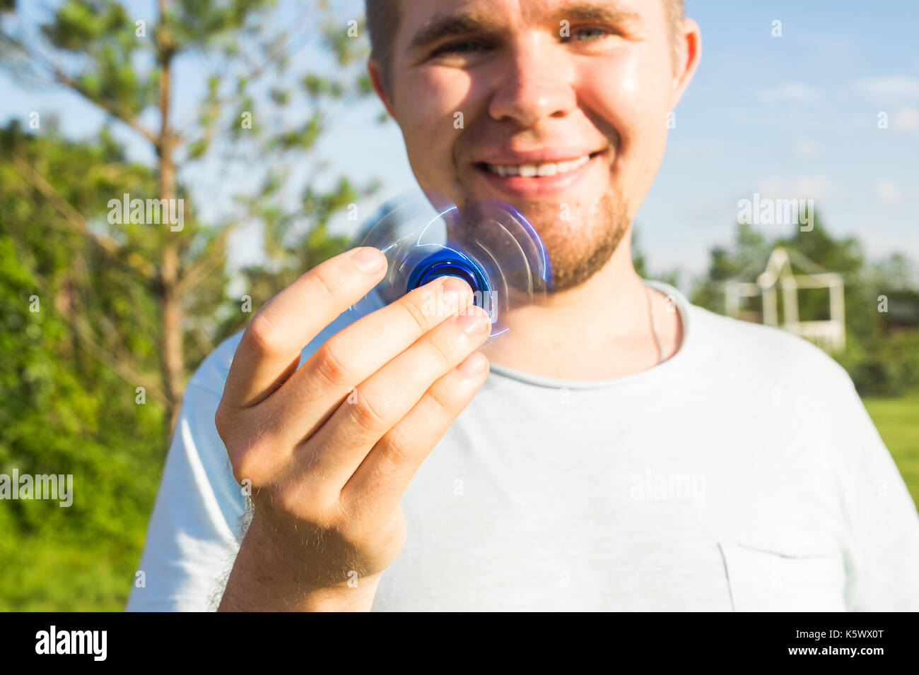 young man playing with a fidget spinner, focus on spinner Stock Photo ...