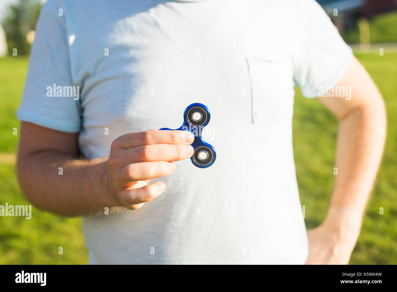 Man hand holding popular fidget spinner toy Stock Photo - Alamy