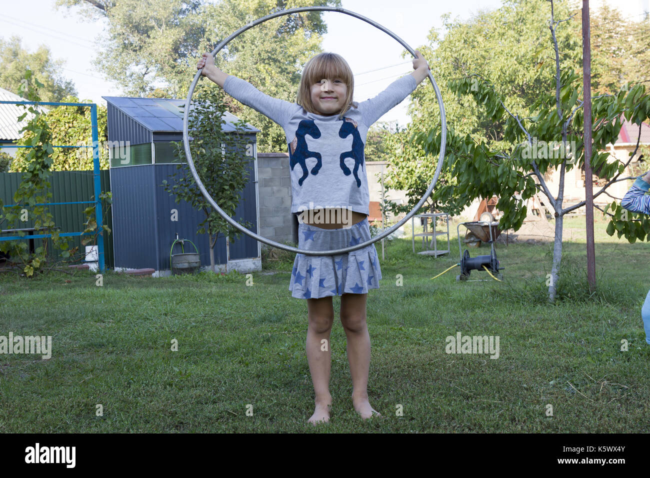 little girl in the park with a hoop Stock Photo - Alamy