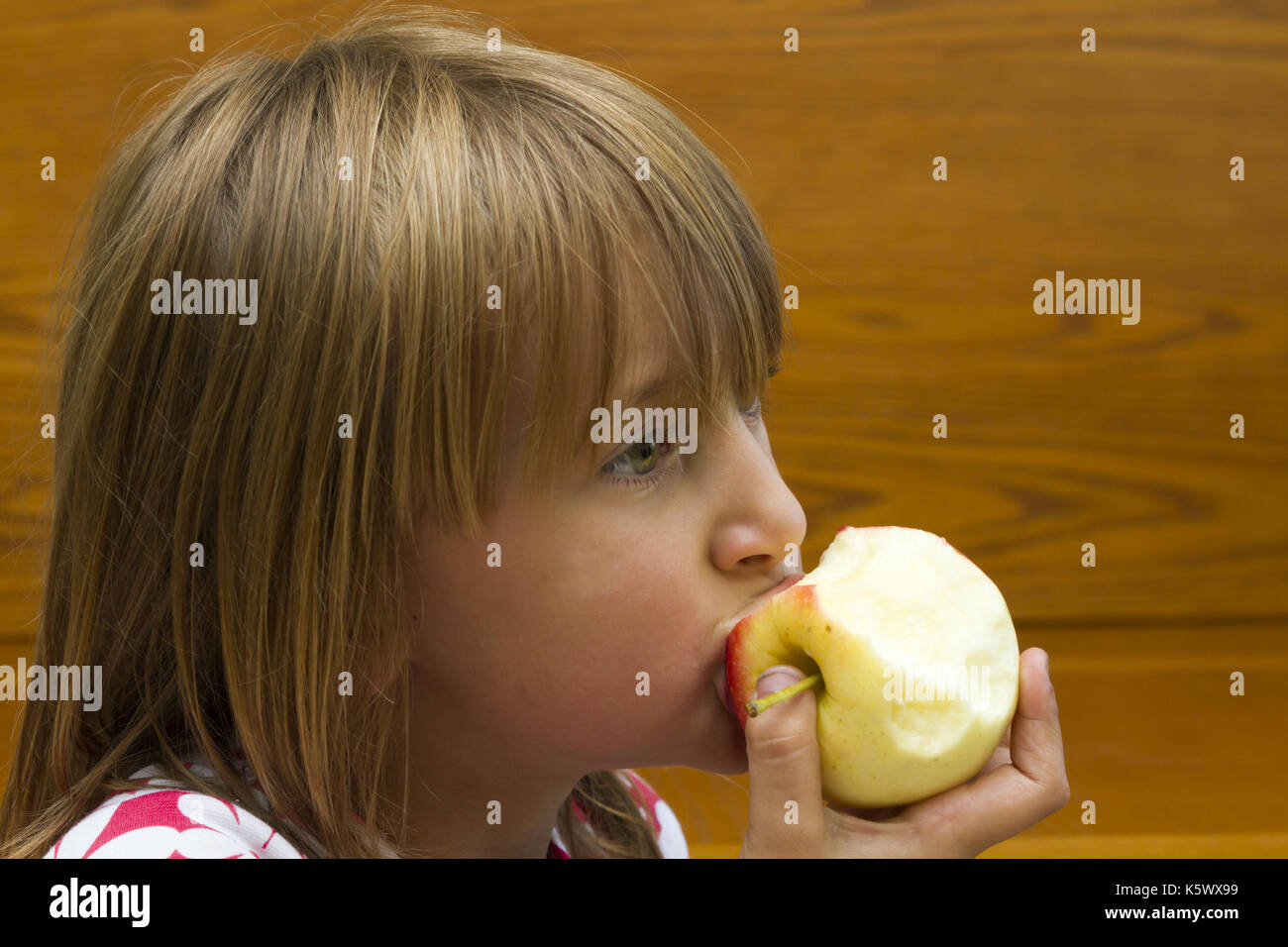 little girl eating an apple Stock Photo - Alamy