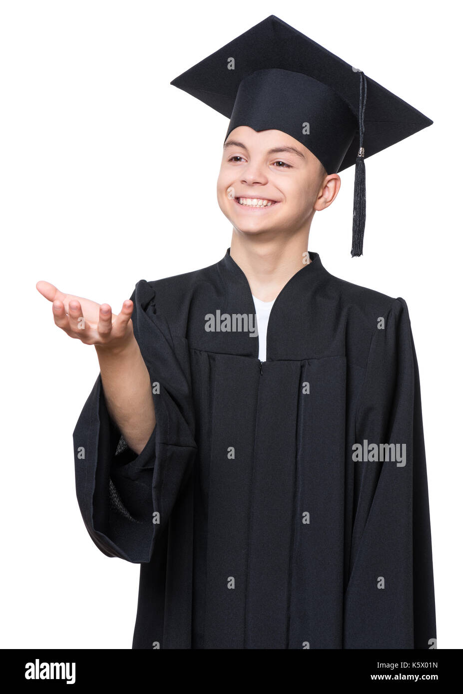 Portrait of graduate teen boy student in black graduation gown with hat ...