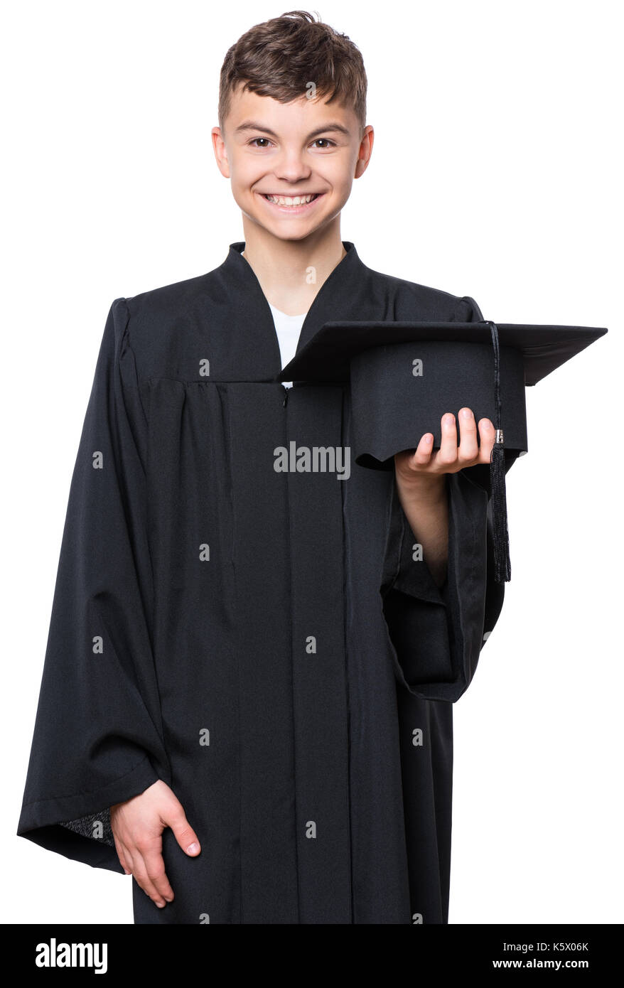 Portrait of graduate teen boy student in black graduation gown with hat ...