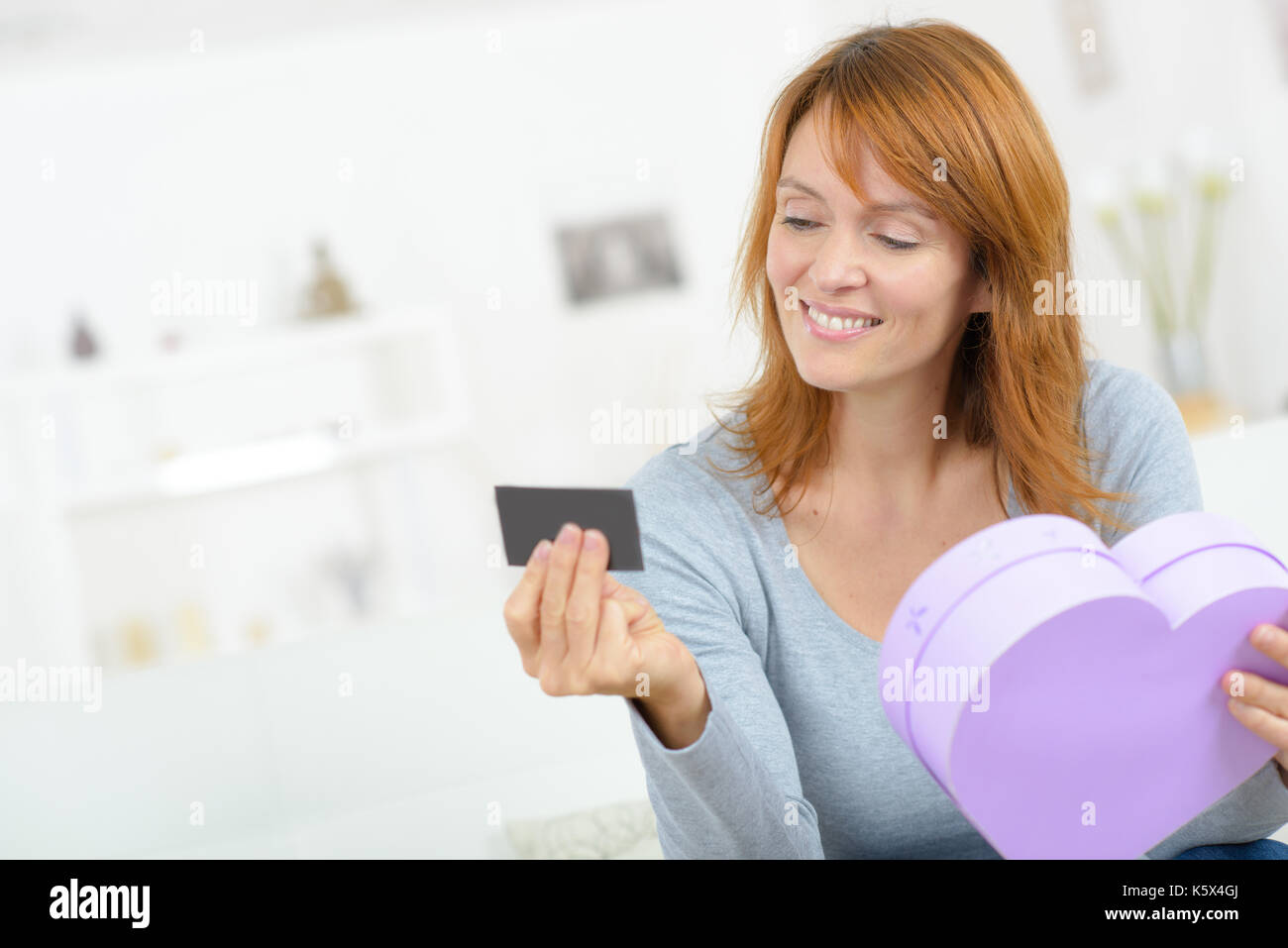 female receiving heart shaped gift and reading card Stock Photo - Alamy