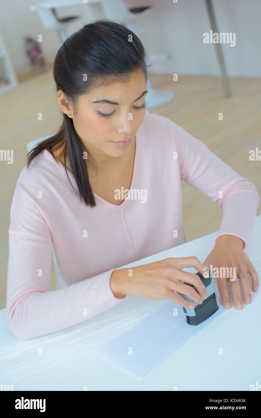 beautiful female stamping the document Stock Photo - Alamy