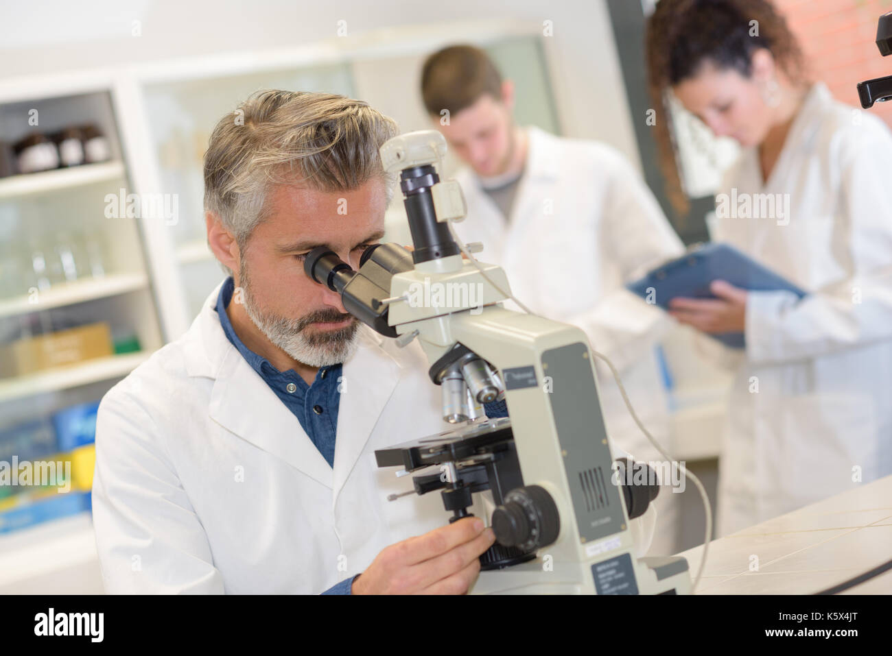 Mature scientist using microscope hi-res stock photography and images ...