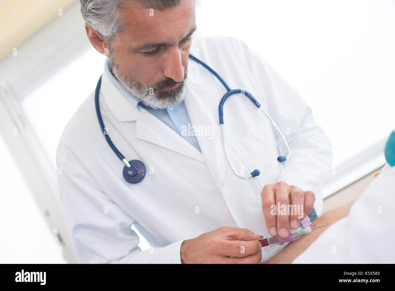 portrait of handsome doctor injecting patient in hospital Stock Photo ...