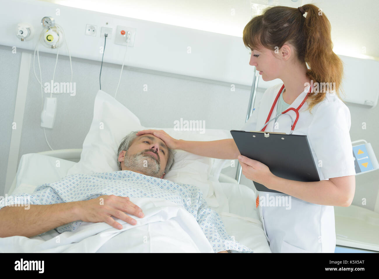 touching the patient's forehead Stock Photo - Alamy
